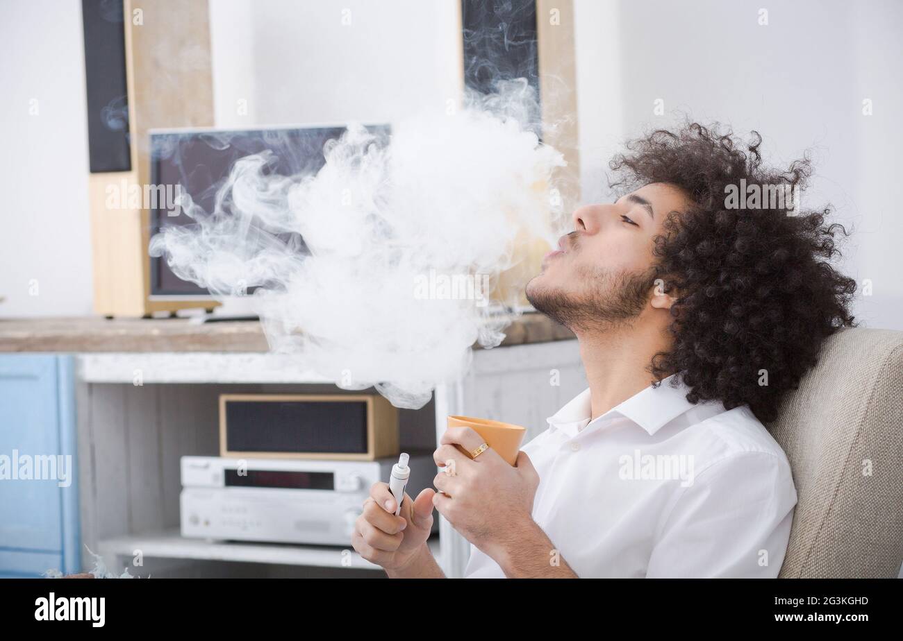 Hipster man smoking at home Stock Photo - Alamy