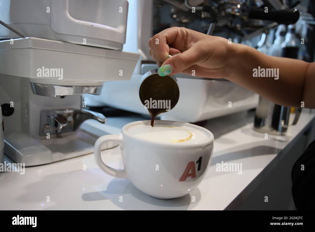 Minsk. Belarus - 06.06.2021: Barista pouring coffee into steamed milk ...