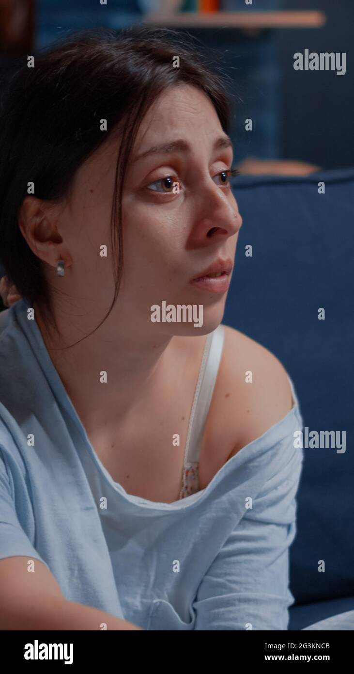 Sensitive woman watching drama movie on tv crying sitting on sofa ...