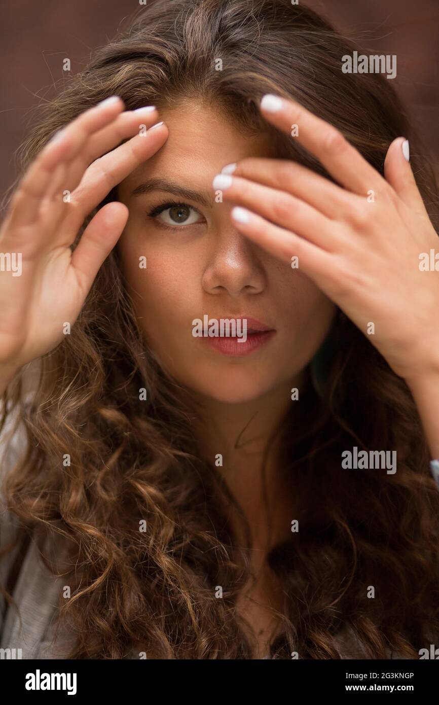 Close up portrait of woman with long brown curly hair Stock Photo - Alamy