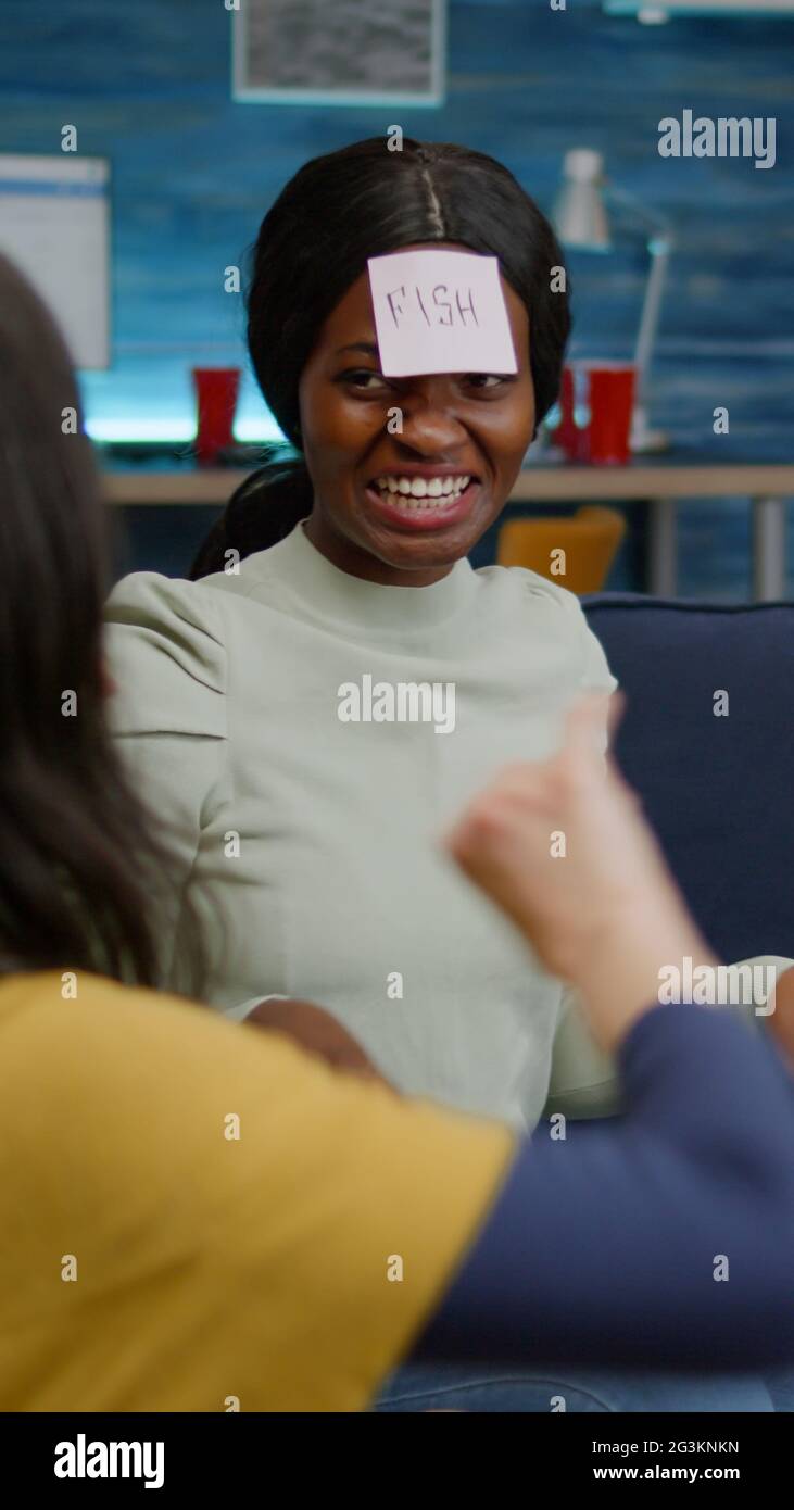 Multi-ethnic friends enjoying time together while relaxing on couch ...