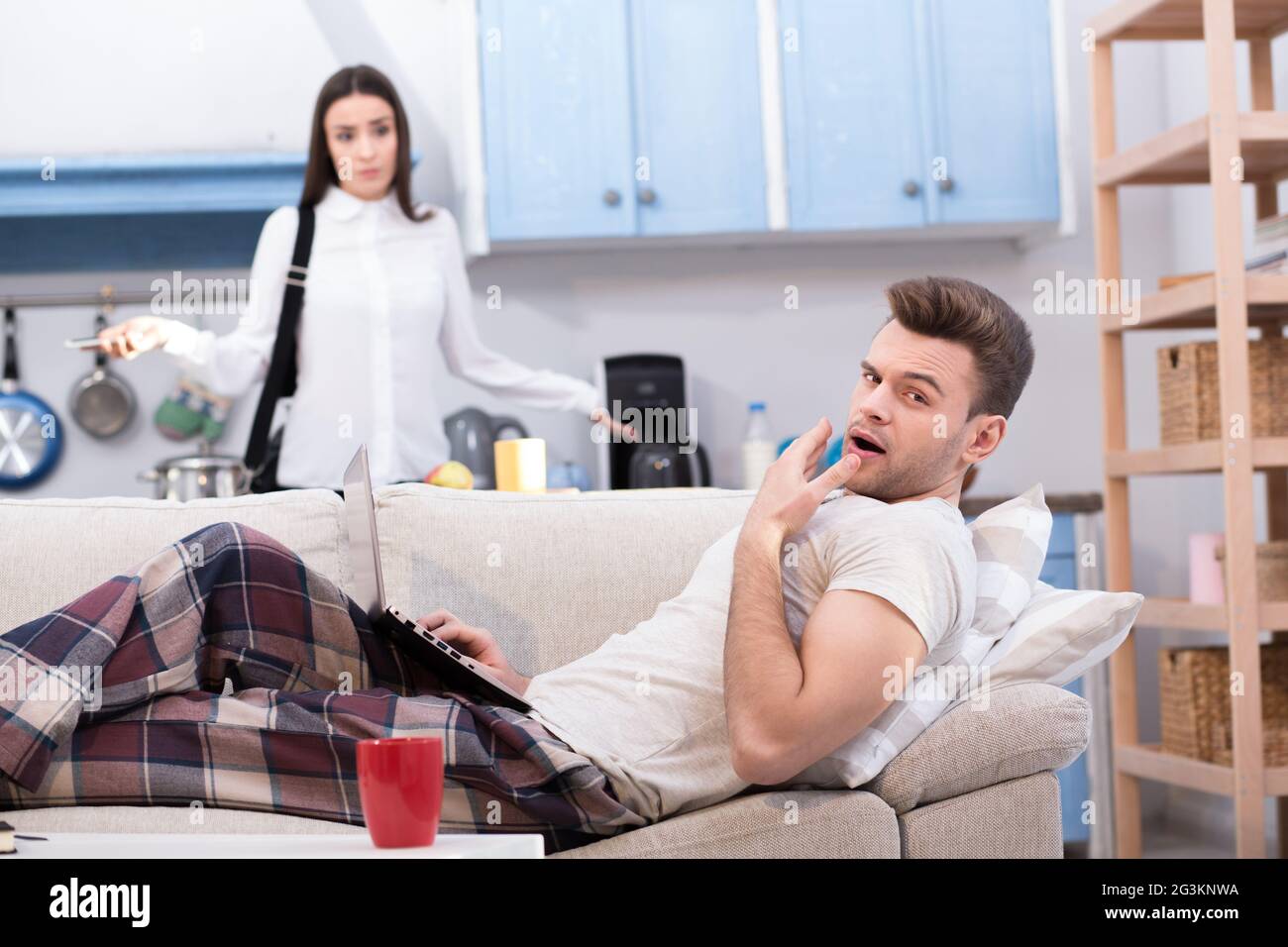 Working woman angry with her lazy husband lying on couch Stock Photo ...