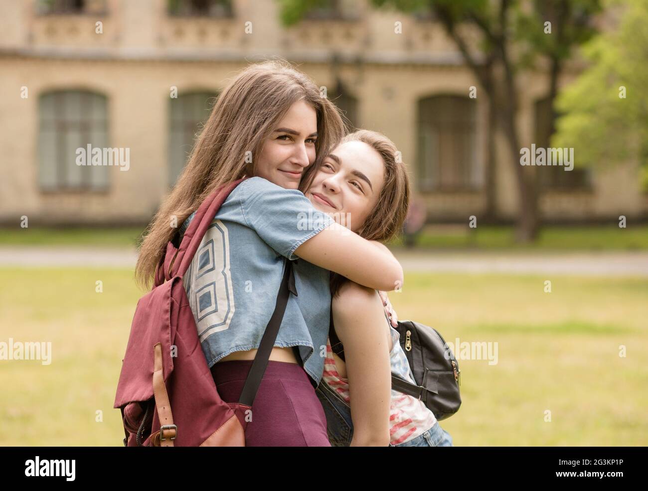 Two female student hug in university campus Stock Photo - Alamy