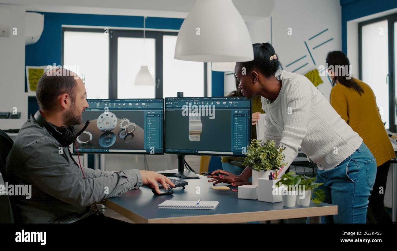 Multiethnic team discussing about industrial project using dual ...