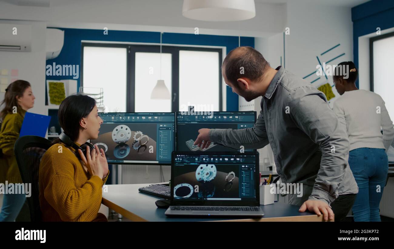 Teamwork sharing ideas about industrial project analysing 3D gears ...