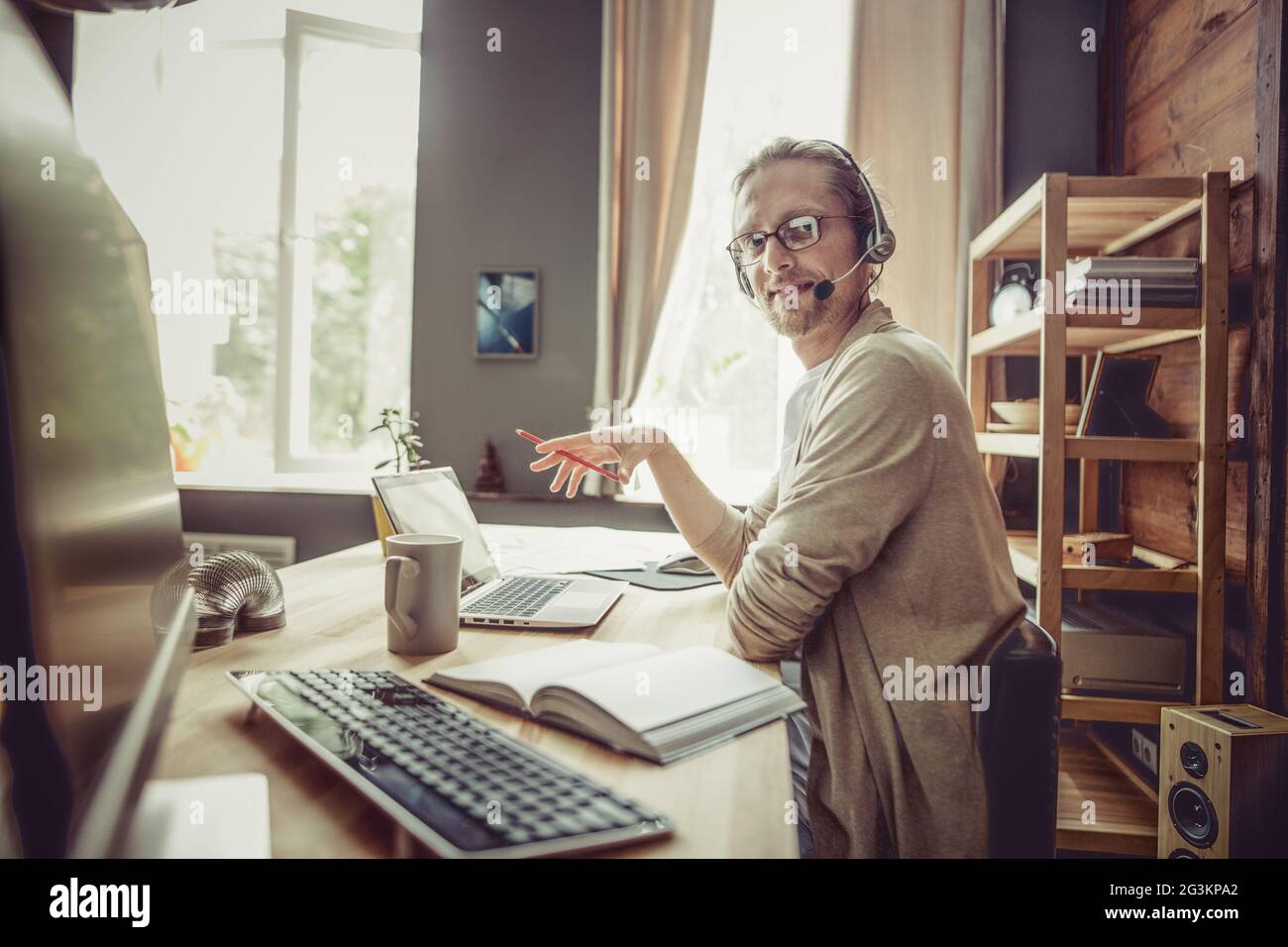 Side view of freelancer using headphones and microphone Stock Photo - Alamy