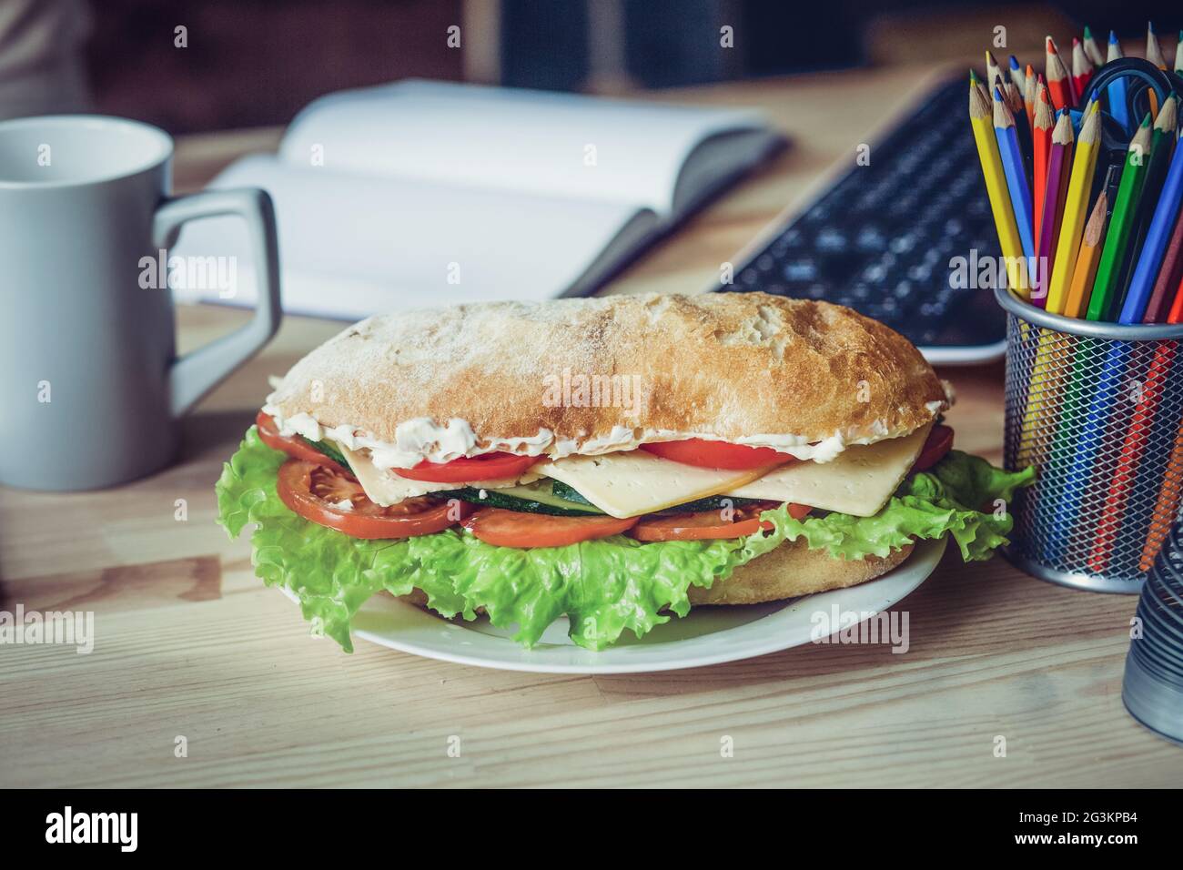 Sandwich and computer keyboard at table in office hi-res stock ...