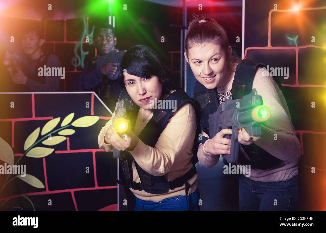 two emotional female laser tag players having fun in multination Stock ...