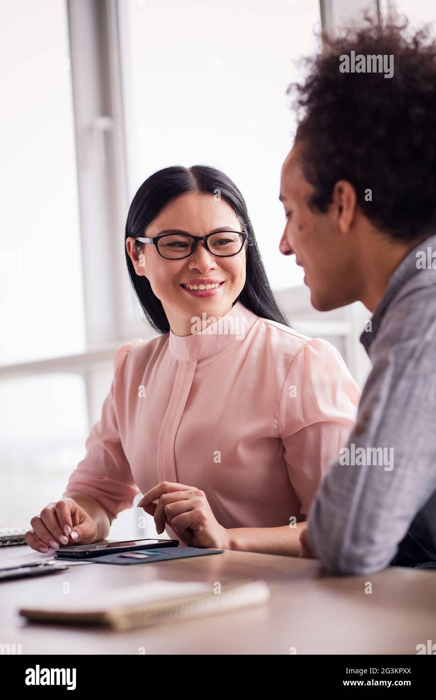 Multiethnic coworkers negotiating at meeting room Stock Photo - Alamy