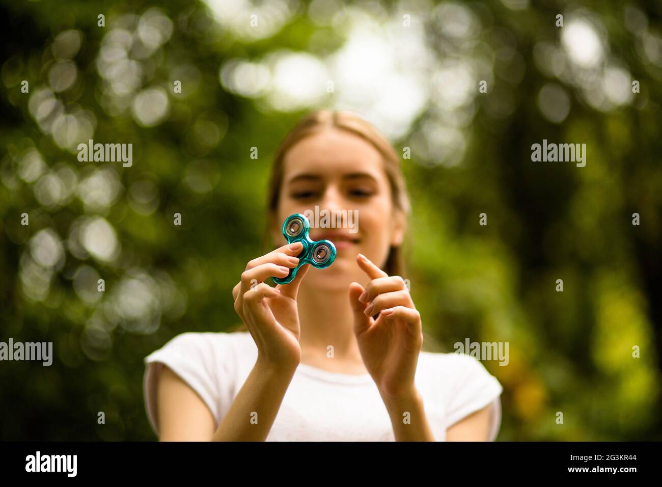 Beautiful young girl outdoors playing with fidget spinner Stock Photo ...