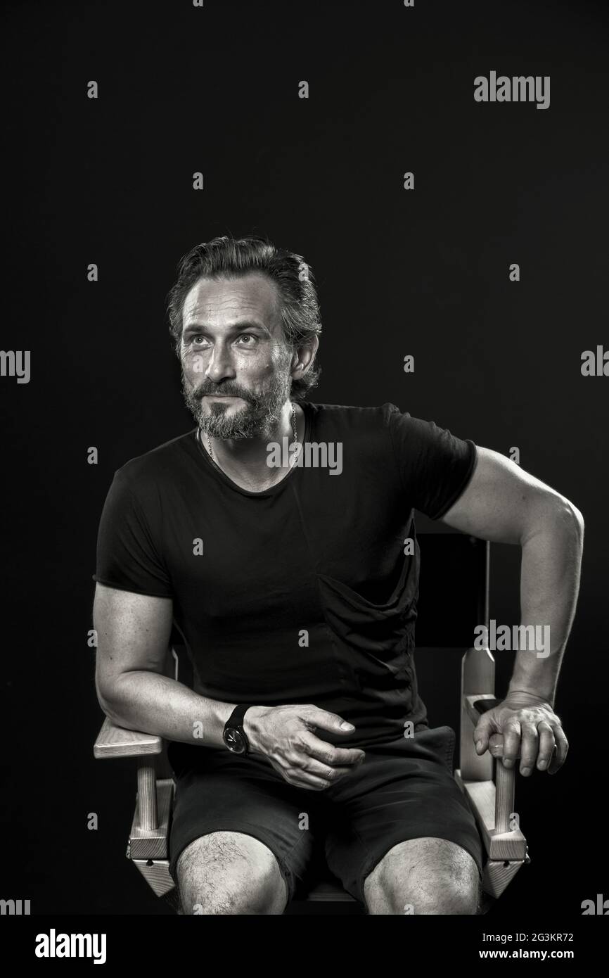 Self confident man with cunning face sitting on chair Stock Photo - Alamy