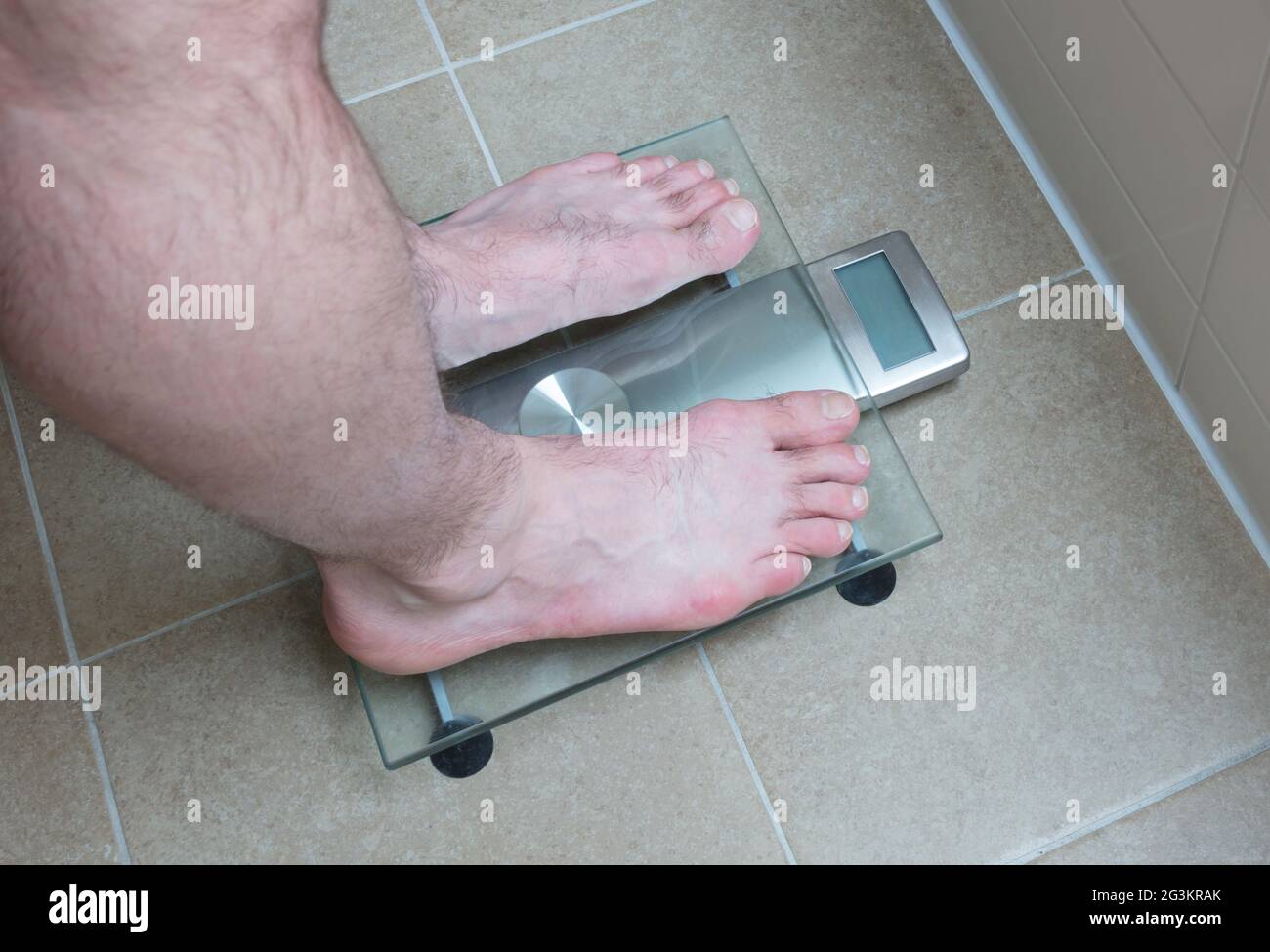 Man's feet on weight scale Stock Photo - Alamy