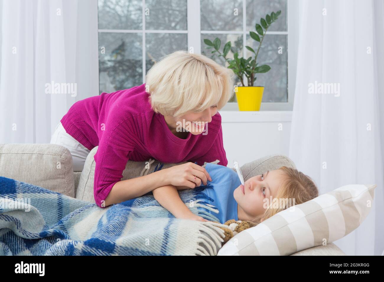 Sick child at home, mom standing close Stock Photo - Alamy