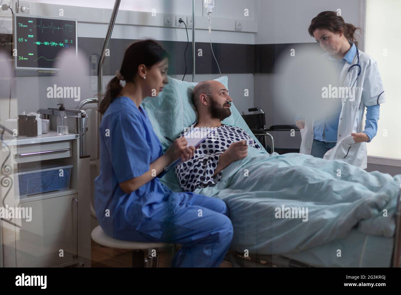 Sick man patient discussing with medical doctors while resting in bed ...