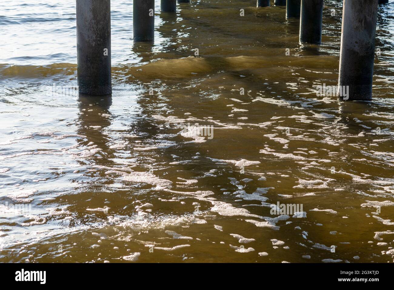 Columnar bridge piers at sunset.View under the bridge into sea with ...
