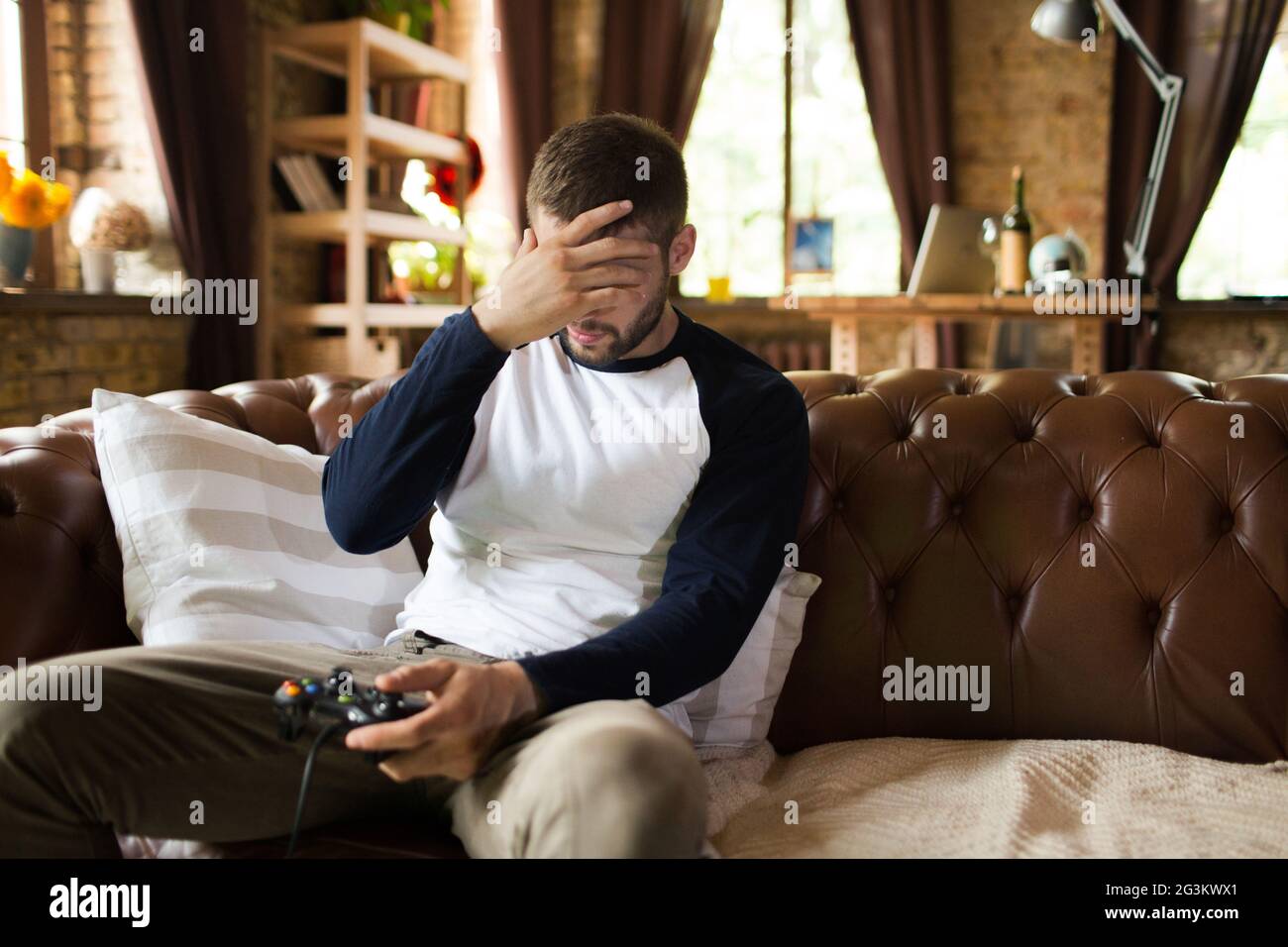 Man playing video games being upset losing game round Stock Photo - Alamy