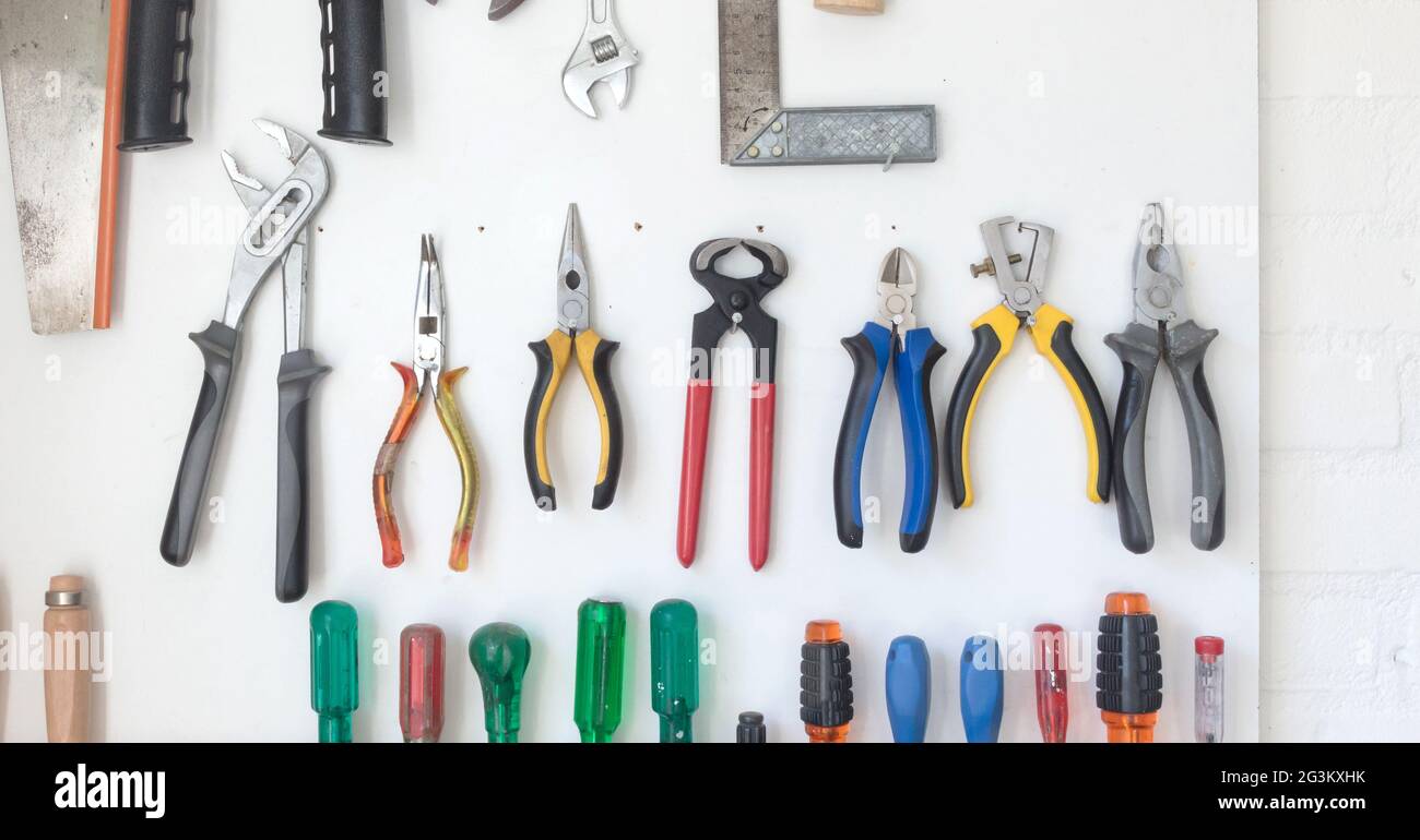 Assorted tools on a white tool board Stock Photo - Alamy