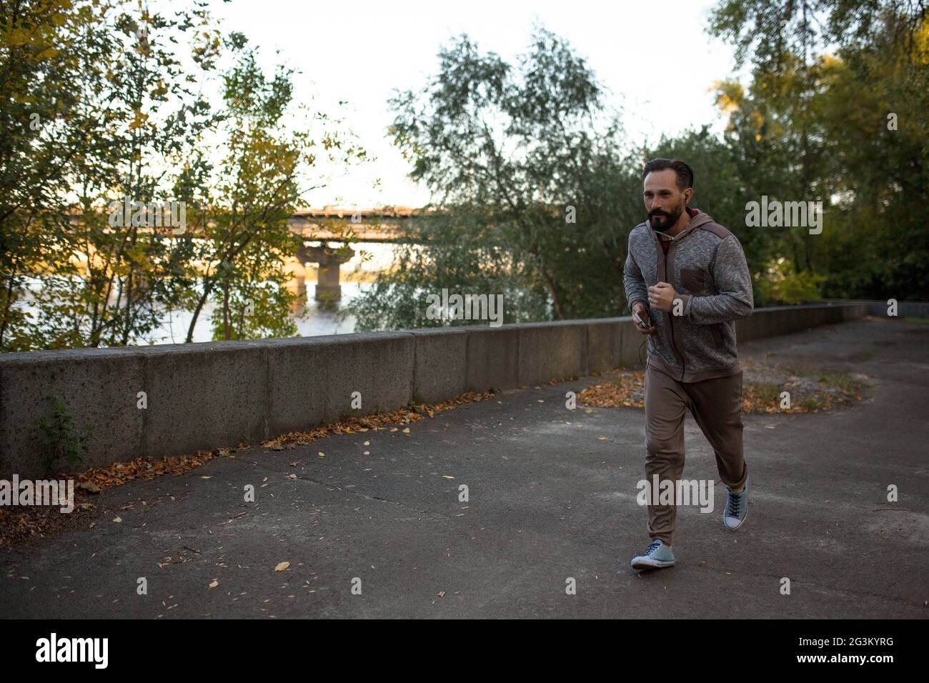 View of man running on river bank in the city Stock Photo - Alamy