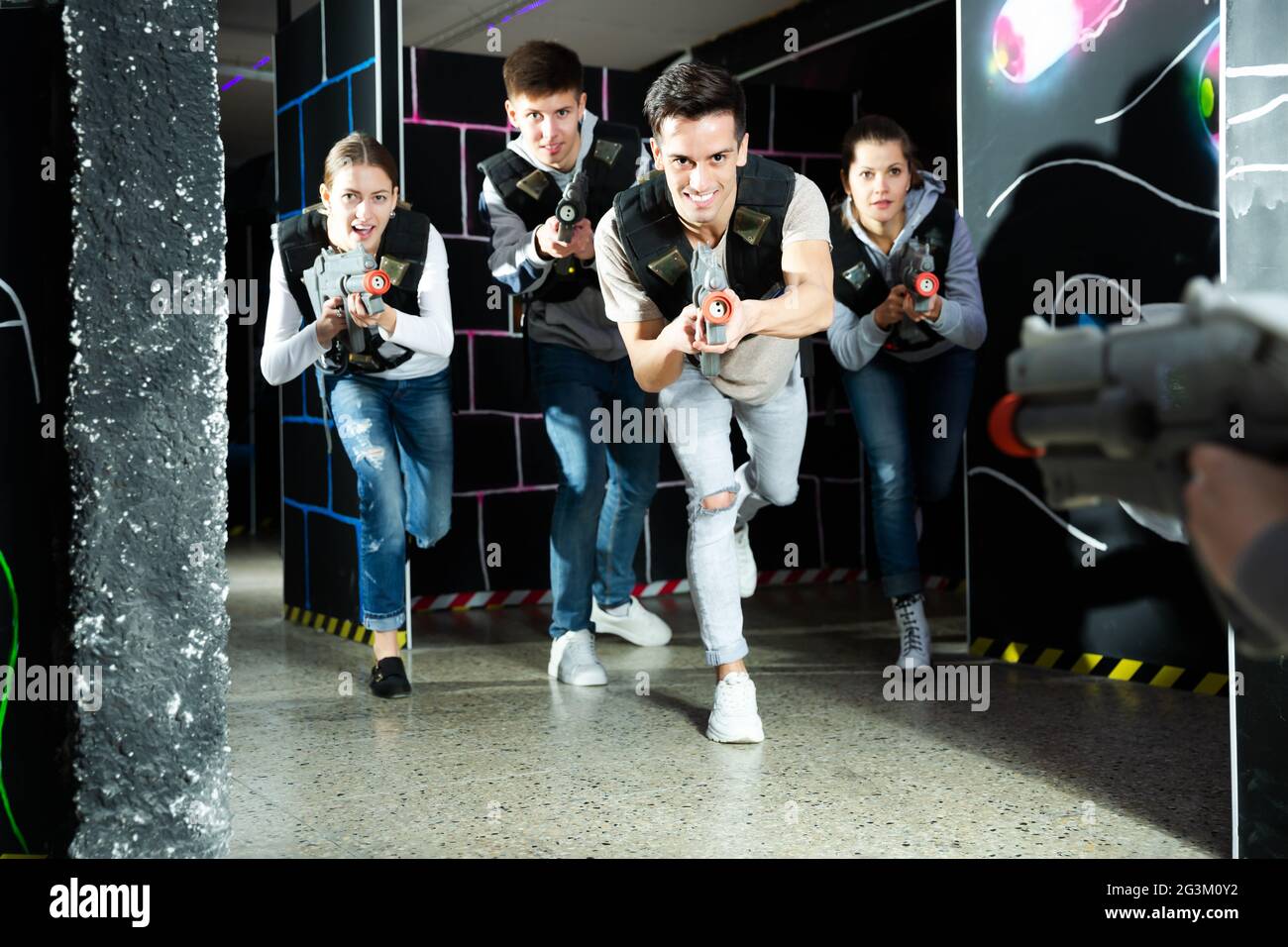 Guy with friends playing laser tag Stock Photo - Alamy