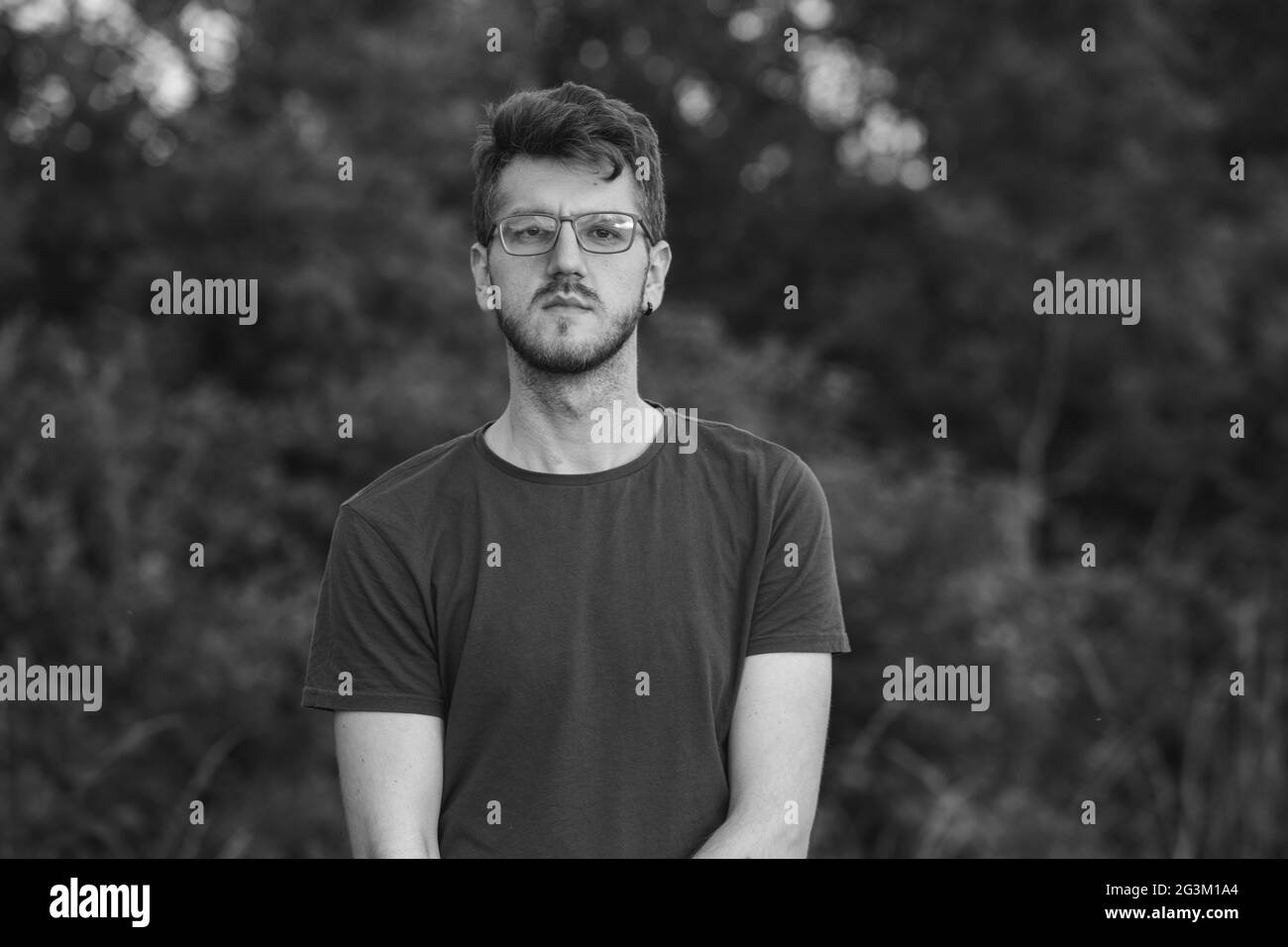 Grayscale shot of a handsome Bosnian man looking at the camera with ...