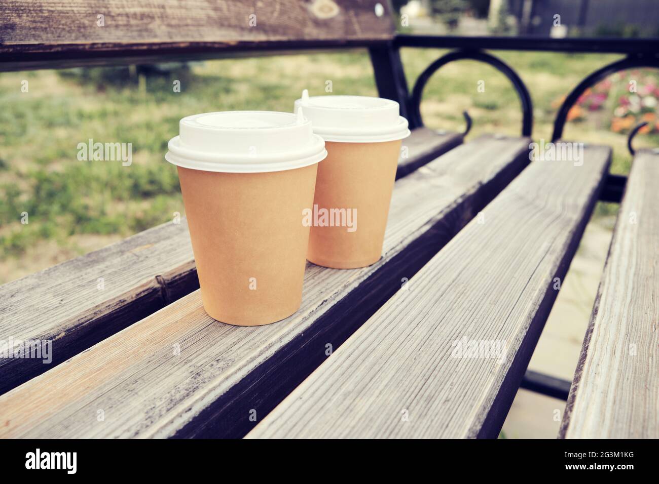 Two cups coffee to take away in park on wooden bench Stock Photo - Alamy