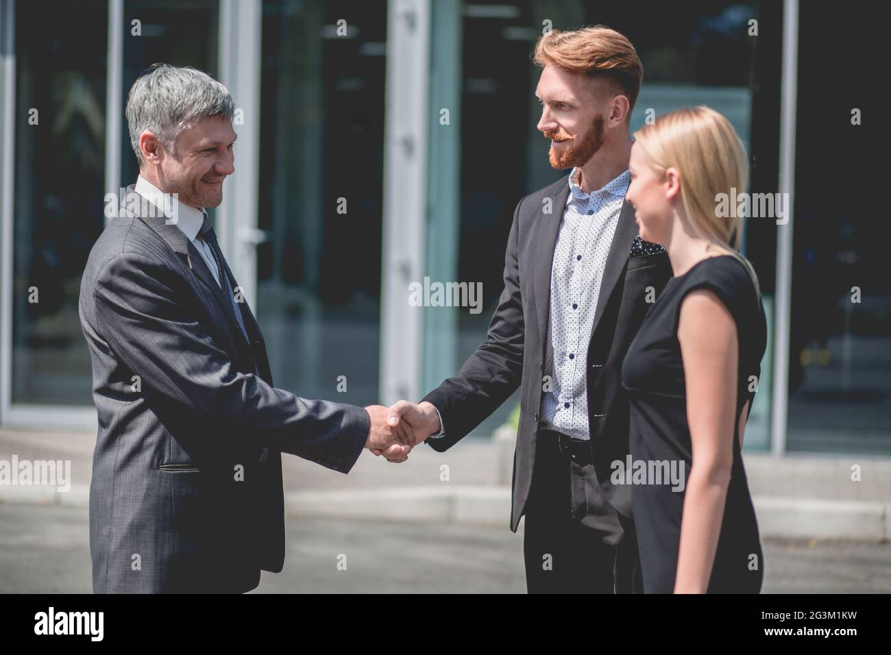 Car dealer agent and young man shaking hands Stock Photo - Alamy