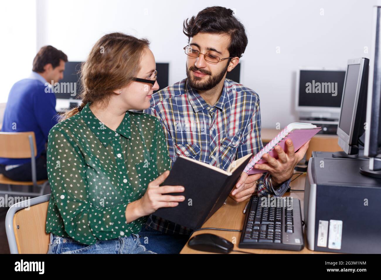 Young people reading book and using pc in library Stock Photo - Alamy