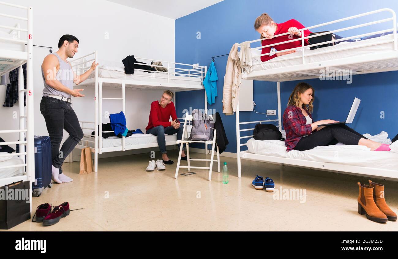 Young men and women friendly interacting while staying in modern comfy ...
