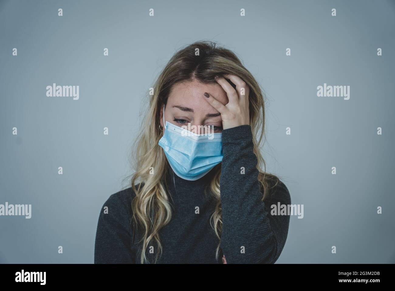 Sad depressed and worried woman with medical face mask feeling upset ...