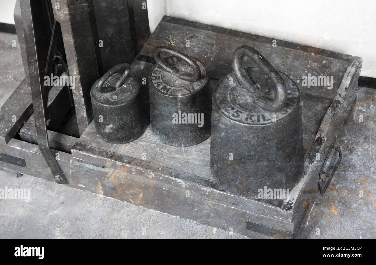 Old brass antique weights with an industrial scale Stock Photo - Alamy