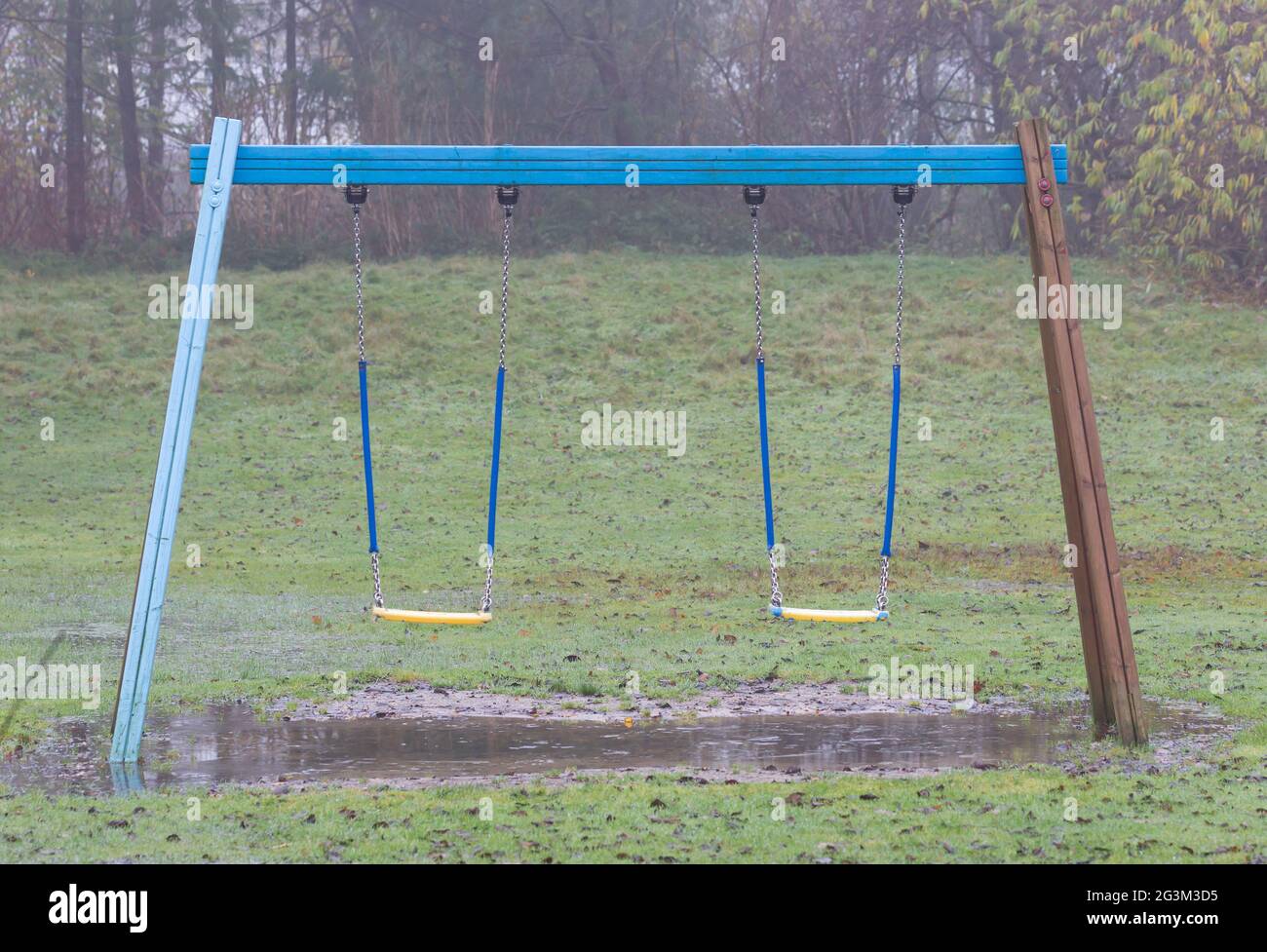 Plastic swing hanging over a puddle Stock Photo - Alamy