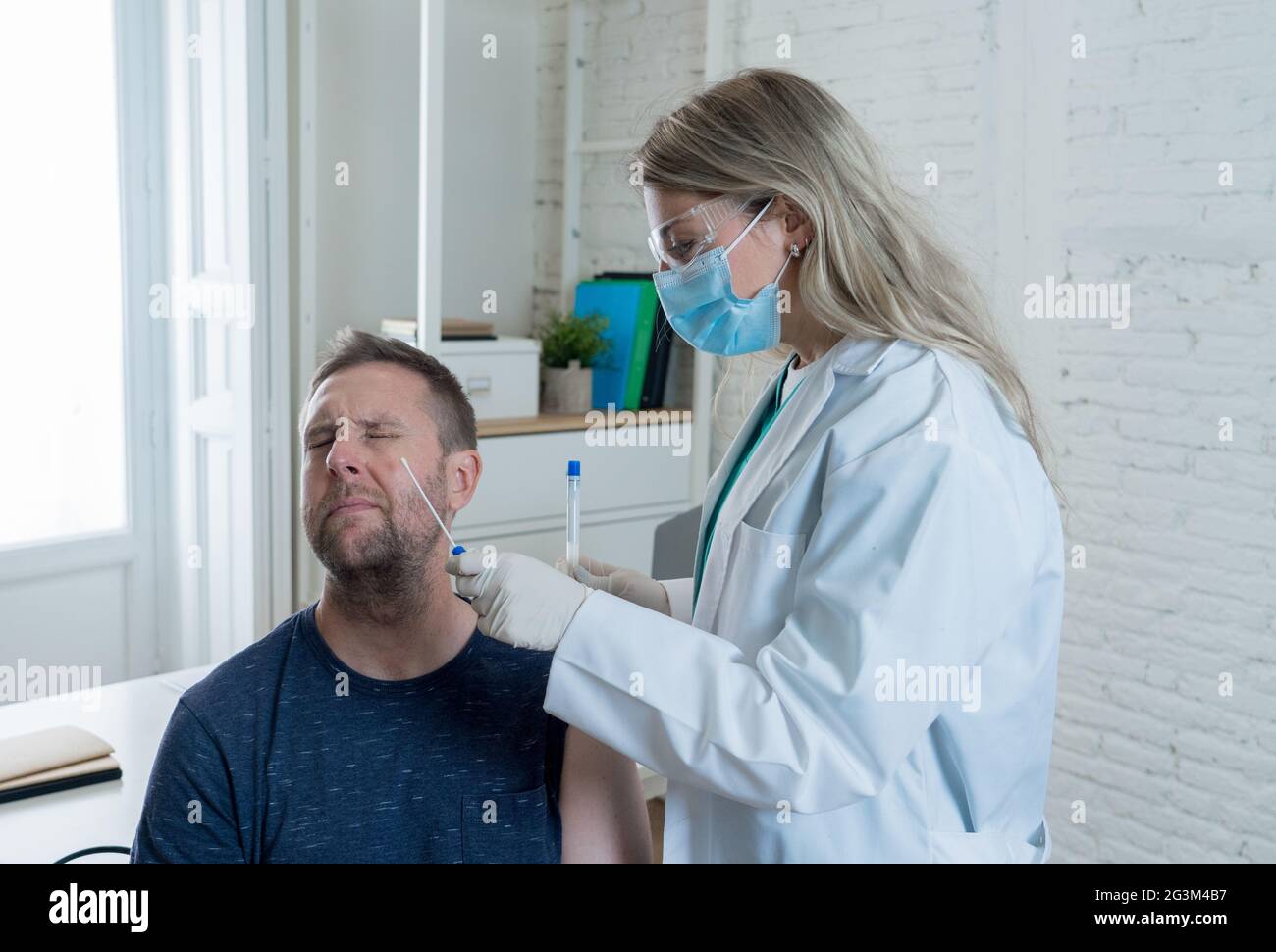 Nurse testing young adult man for coronavirus infection taking rapid ...