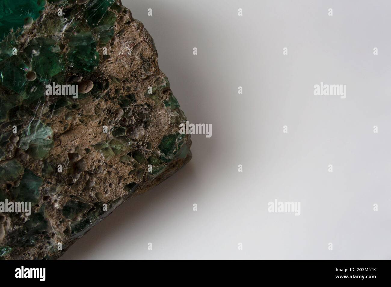 Textured green mineral rock detail on white background with a copy ...
