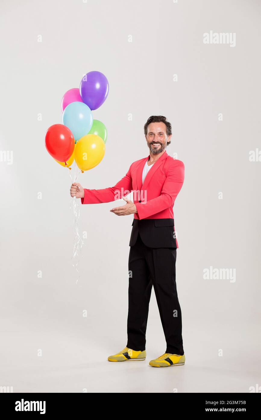 Man in red jacket with colorful balloons Stock Photo - Alamy
