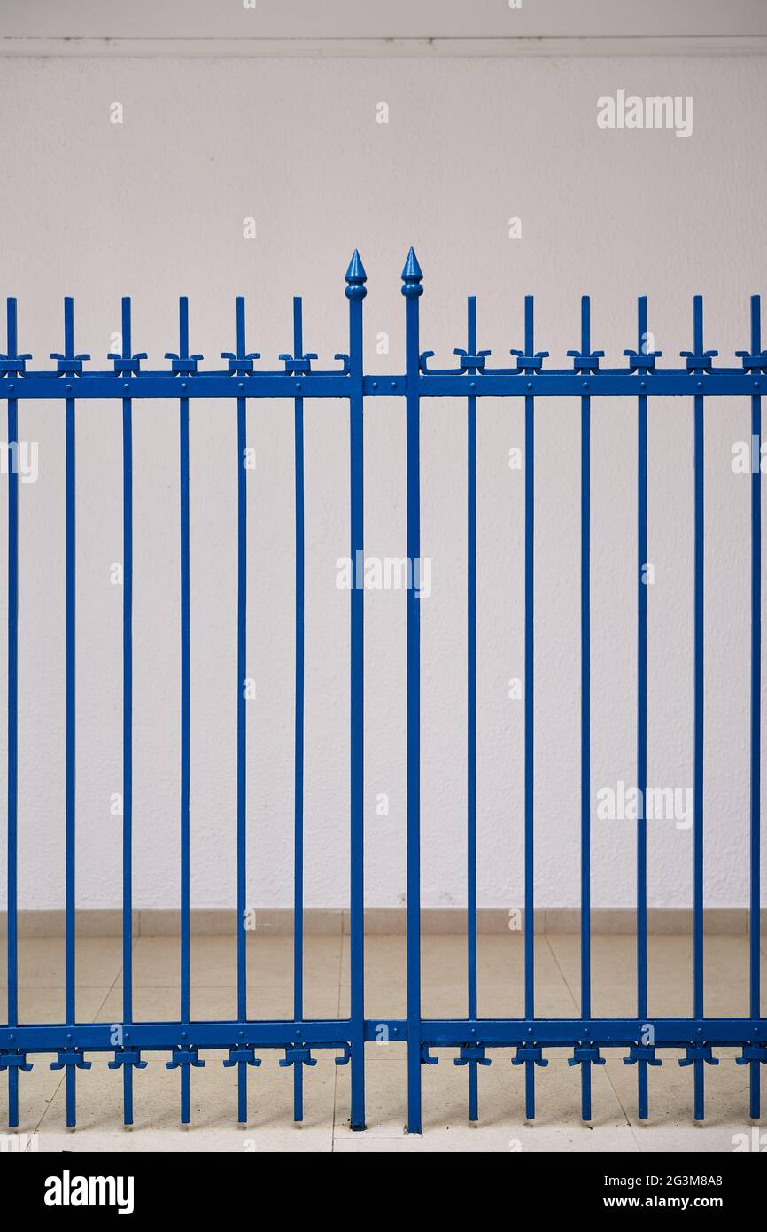 Closed blue metal gate near white wall Stock Photo - Alamy