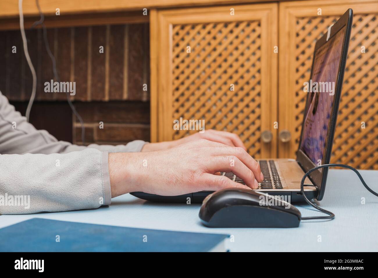 The hands of an unknown person using a laptop, moving the cursor with ...