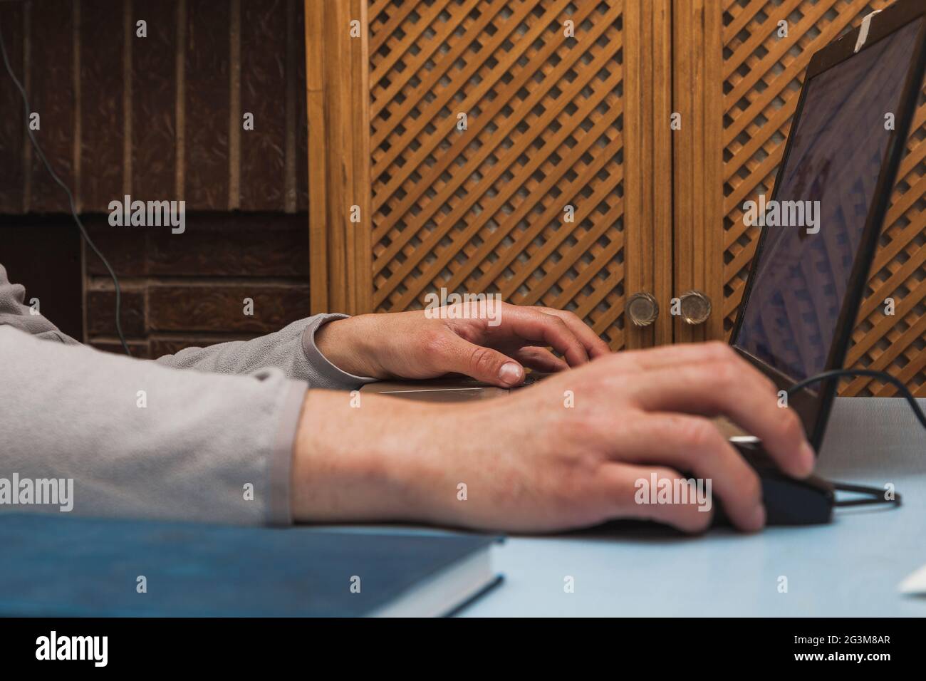 The hands of an unknown person using a laptop, moving the cursor with ...