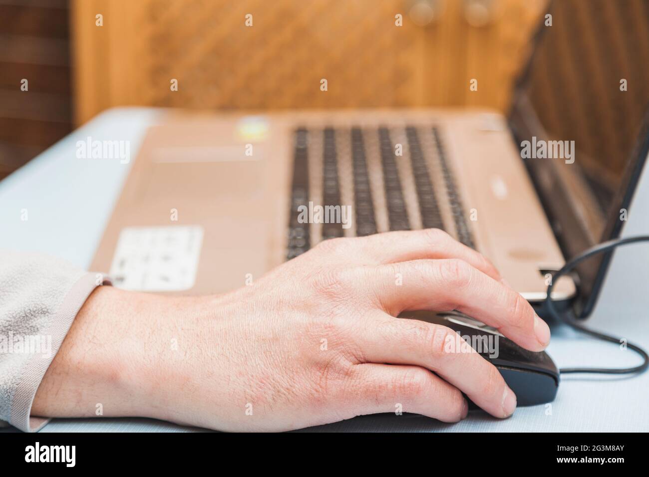 The hands of an unknown person using a laptop, moving the cursor with ...