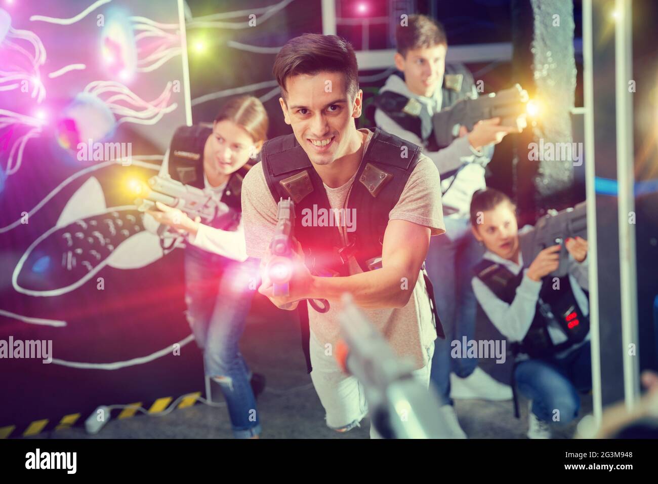 Guy aiming laser gun during lasertag game Stock Photo - Alamy
