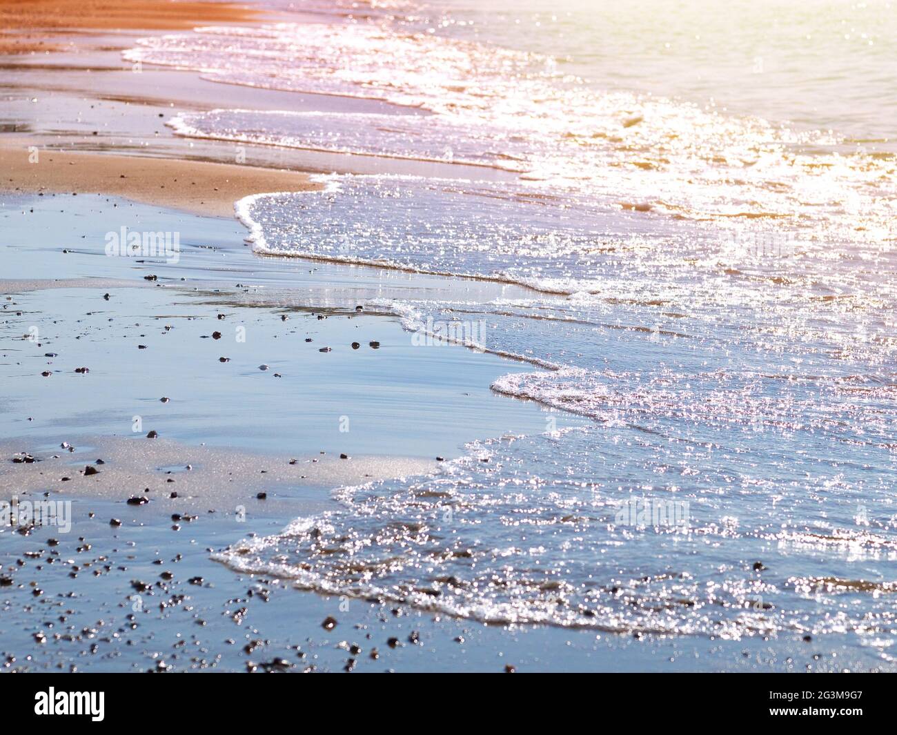 sea waves on sand beach, toned, sunlight effect Stock Photo - Alamy