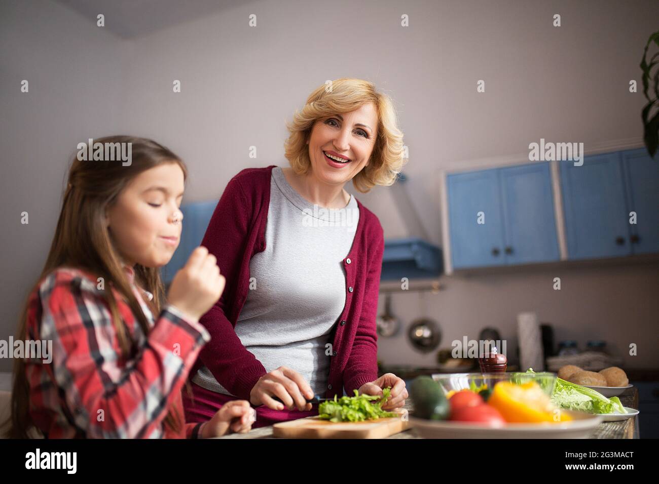 Grandmother and cute granddaughter cooking salad Stock Photo - Alamy