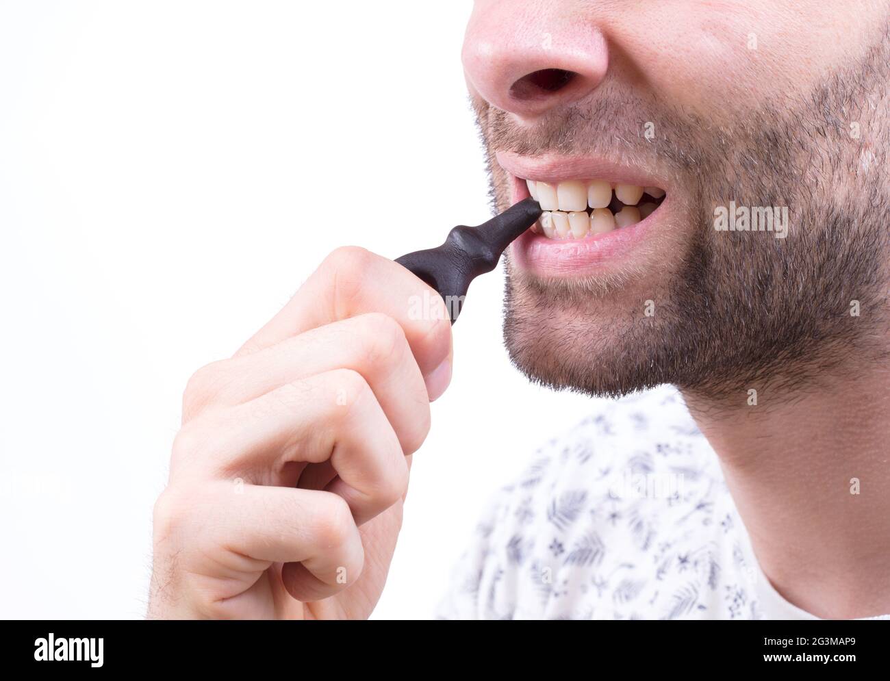 Man eating typicaly dutch candy called 'Dropsleutel' (candy key Stock ...