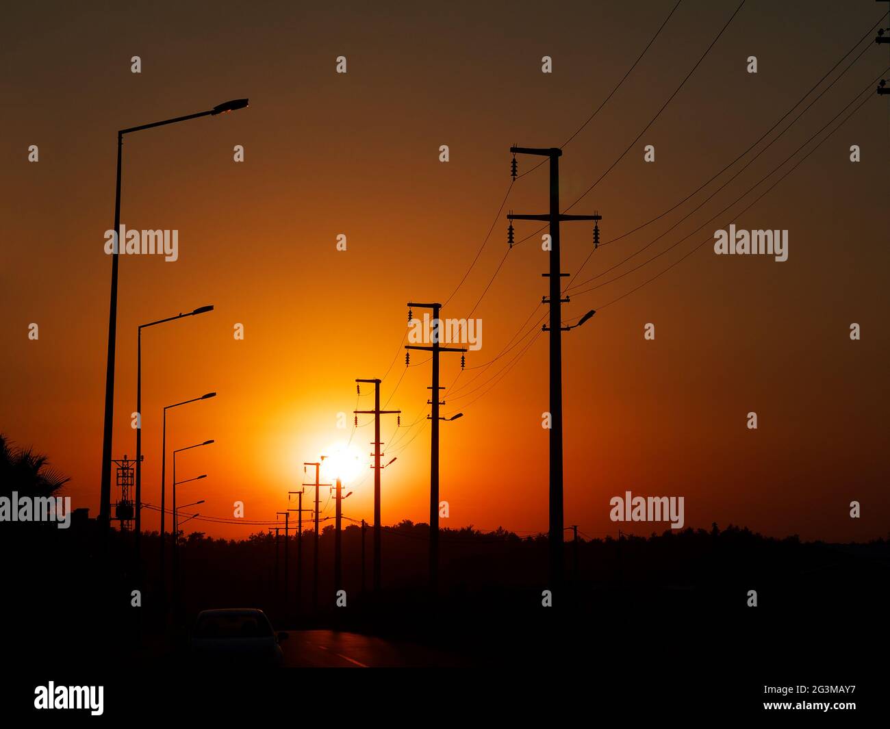 road with power line and lamp posts in sunset Stock Photo - Alamy