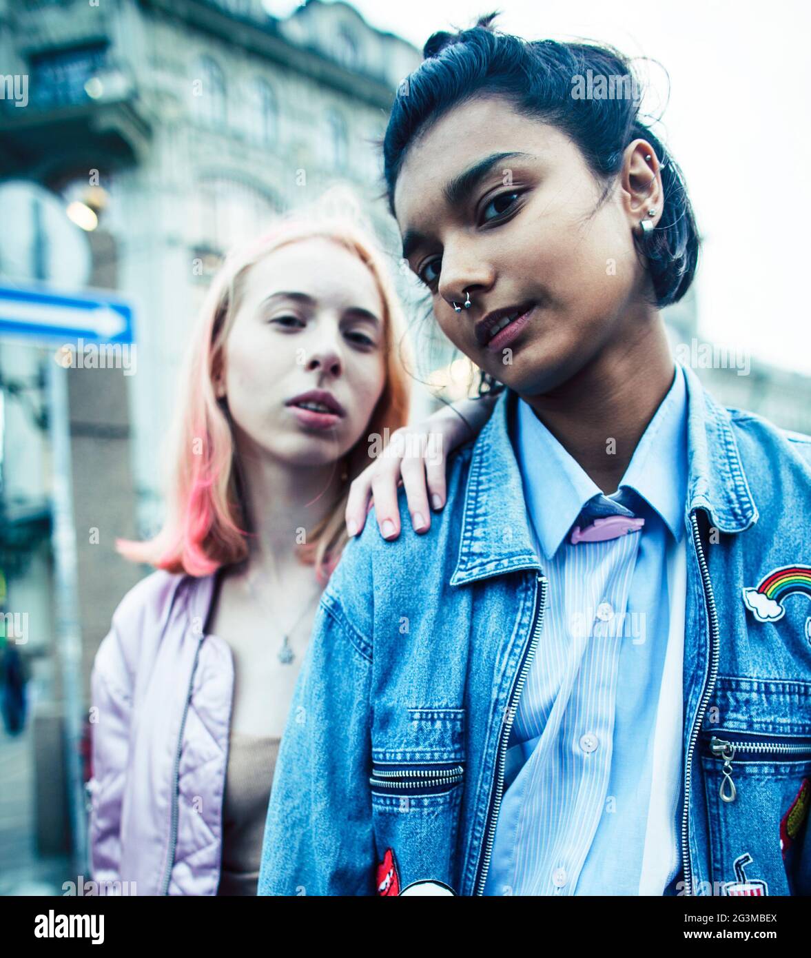 Two teenage girls infront of university building smiling, having fun ...