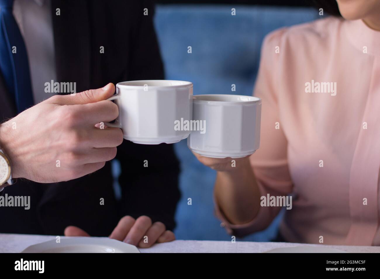 Two partners working together and having coffee Stock Photo - Alamy