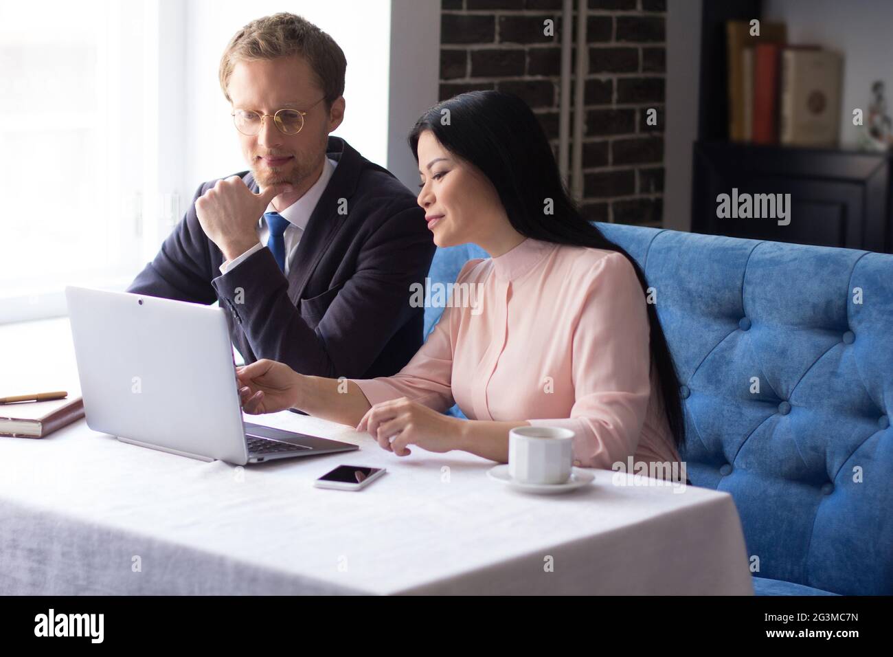 Two partners working together and having coffee Stock Photo - Alamy