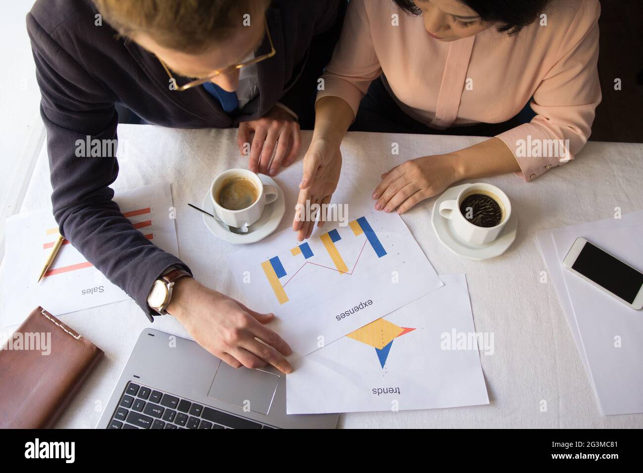 Two partners working together and having coffee Stock Photo - Alamy