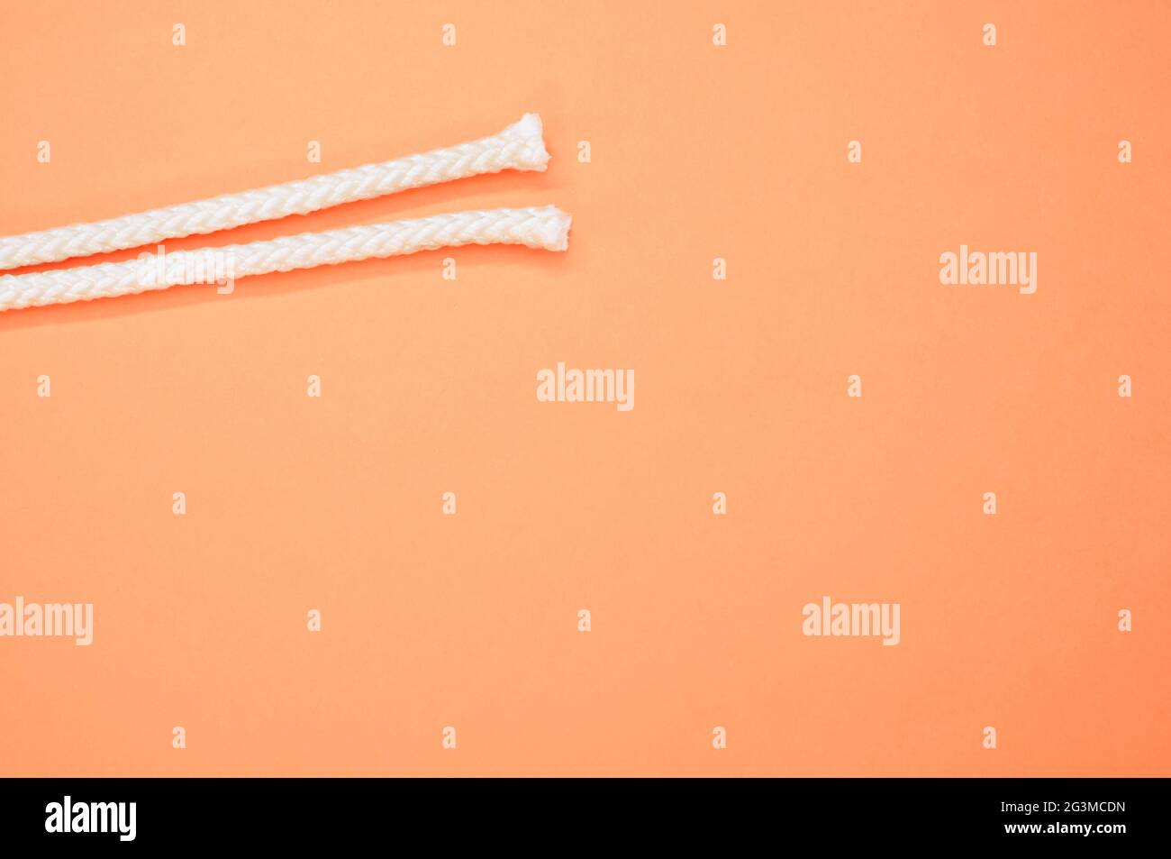 Top view of two white, short ropes isolated on the pastel orange ...