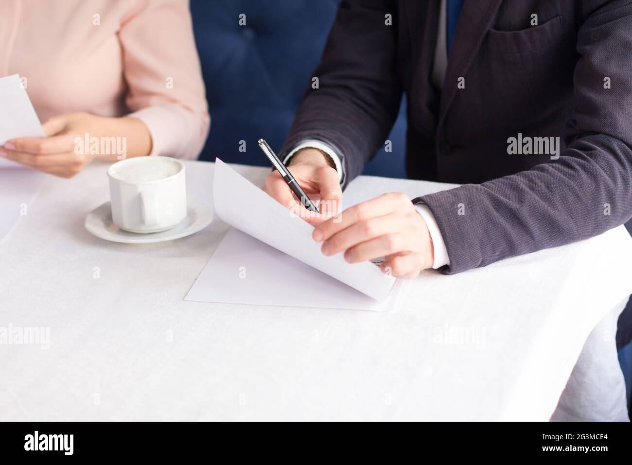 Three business people sign agreement at restaurant Stock Photo - Alamy