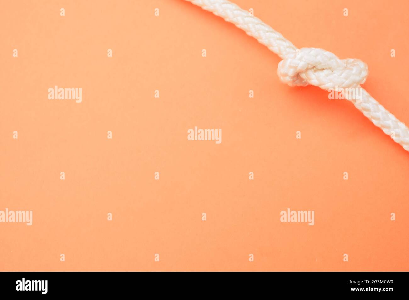 Closeup shot of a rope knot isolated on a peach color background Stock ...